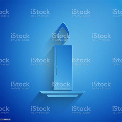 종이 컷 파란색 배경에 고립 된 촛대 아이콘에 불타는 촛불 구식 조명 촛불 불타는 불꽃이 있는 원통형 촛불 스틱 종이 아트 스타일입니다 벡터 일러스트레이션 교회에 대한 스톡