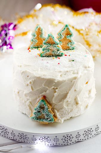 흰색 버터 크림 유약 서리와 새해 크리스마스 축제 수제 케이크는 배경에 화환과 조명 녹색 크리스마스 트리 쿠키로 장식 축하용 베이커리 스타일 케이크 겨울에 대한 스톡 사진