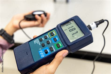 hand holding digital handheld light lux meter intensity of light with