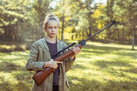 Premium Photo Girl Shooting From The Air Rifle In The Forest