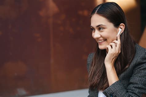 도시의 일몰에 무선 헤드폰을 사용하여 휴대 전화로 화상 통화를하는 젊은 웃는 사업가 공간을 복사합니다 온라인 커뮤니케이션 개념 원격 근무 원격 교육 25 29세에 대한 스톡