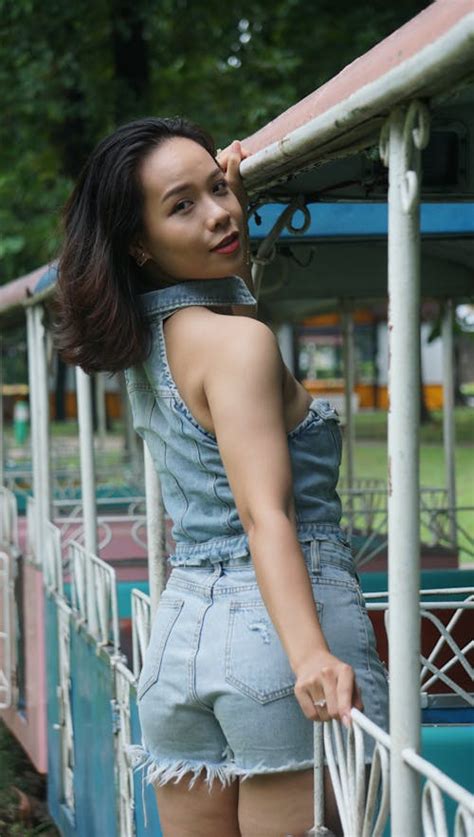 검은 머리 긴 머리 뒷모습 미소 짓는 서 있는 수직 쐈어 여성 코트 패션 사진 포즈를 취하는에 관한 무료 스톡 사진