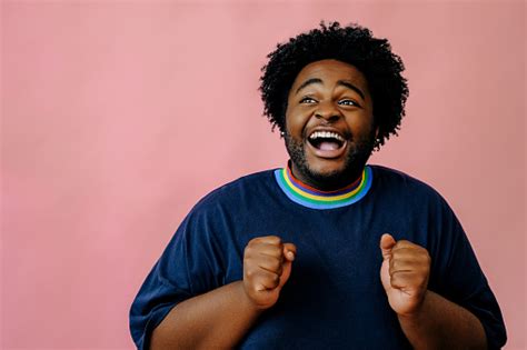 핑크 배경을 통해 스튜디오에서 포즈를 취하는 젊은 행복한 아프리카 계 미국인 남자 20 29세에 대한 스톡 사진 및 기타 이미지 20 29세 긍정적인 감정 표현 남자