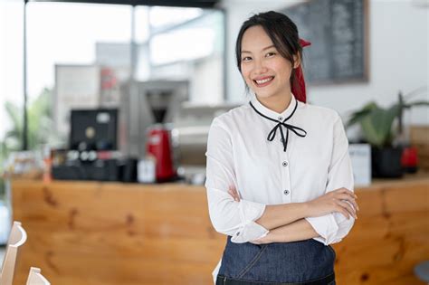 커피 비즈니스 소유자 앞치마에있는 매력적인 젊은 아름다운 백인 바리스타와 커피 숍 카운터의 카메라에 웃고있는 십자가 손 경영자에 대한 스톡 사진 및 기타 이미지 Istock