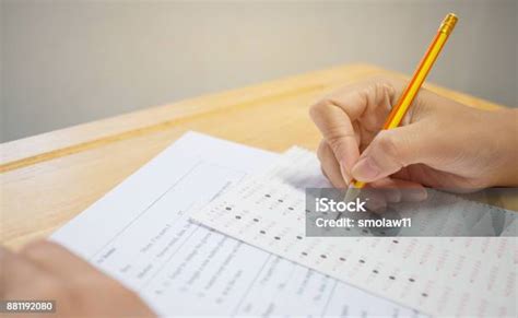 학생 손 시험 시험 대 한 답변의 광학 모양에 연필과 행 책상의 자 하 고 교실에서 시험에 영어 종이 시트를 들고와 시험 룸을