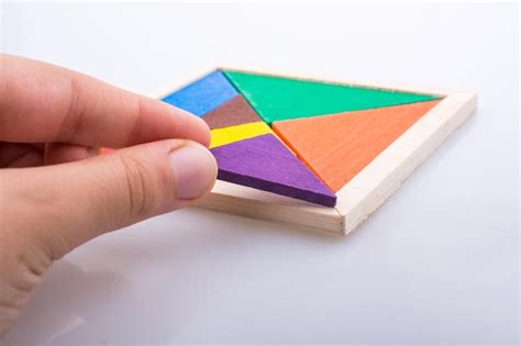 main tenant une pièce manquante dans un puzzle tangram photo premium