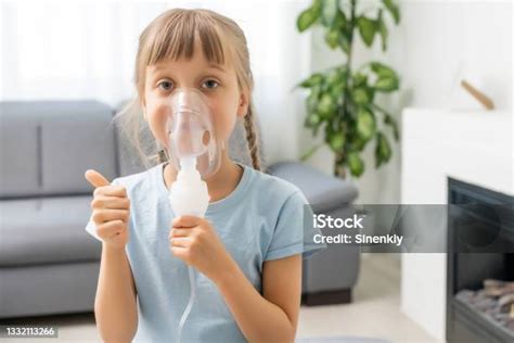 아이 소녀는 분무기로 흡입을합니다 흡입기를 손에 들고 집에서 흡입기를 통해 호흡하는 아픈 아이 건강관리와 의술에 대한 스톡 사진 및 기타 이미지 Istock
