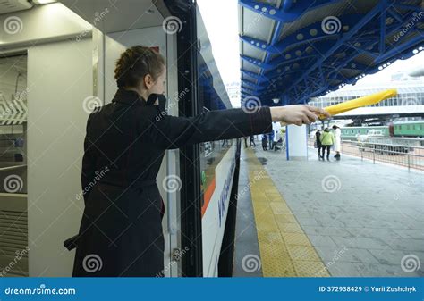 Female Train Conductor Signaling Departure Of The Passenger Train Standing On The Platform The