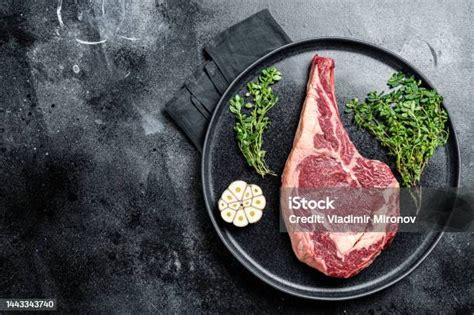드라이 에이징 카우보이 또는 립아이 스테이크 허브를 곁들인 생 쇠고기 고기 검은 배경입니다 평면도 복사 공간 0명에 대한 스톡