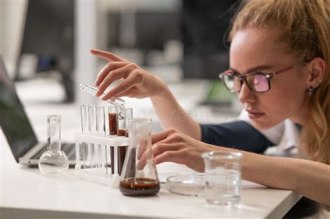 Caucasian Woman In A Medical Gown Doing Laboratory Experiments Stock
