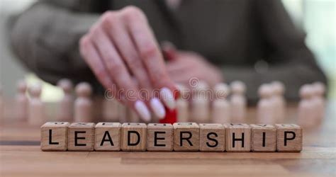 Word Leadership And A Hand Placing Red Figurine And A Group Of