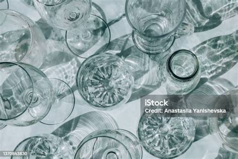 아름다운 다른 안경은 햇빛에 흰색 배경에 서서 그림자를 만듭니다 하드 라이트 긴 그림자 음료 알코올 칵테일의 창조적 인 개념 유리 제품 개념 크리스탈 유리제품에 대한 스톡