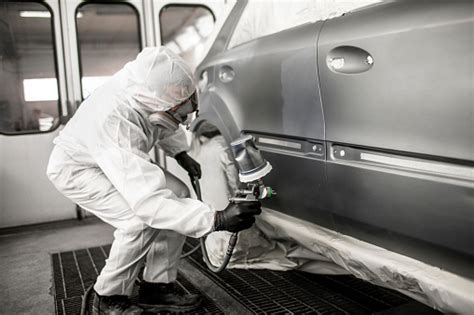 페인트 스프레이 건을 사용하여 페인팅 부스에서 자동차의 측면을 그리는 자동차 컬러스트 스프레이 도장에 대한 스톡 사진 및 기타