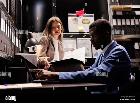 Police Officers Analyzing Criminology Report Working Overtime At Criminal Case In Arhive Room