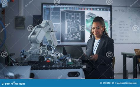 Portrait Of Smiling Black Developer Using Laptop While Working With Robotic Arm In Modern