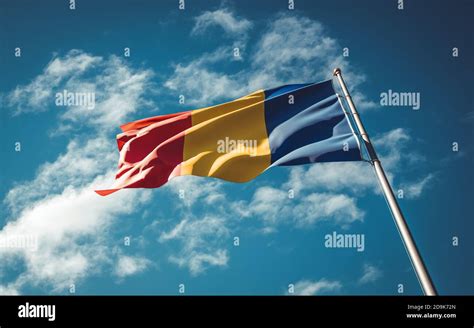 Beautiful National State Flag Of Romania Fluttering At Sky Background