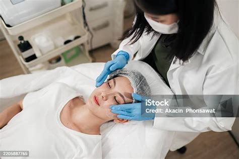 미용사는 미용 주사를 준비하기 위해 얼굴을 닦습니다 뷰티 클리닉에서 얼굴 치료를 받는 아시아 여성 20 24세에 대한 스톡 사진 및 기타 이미지 Istock