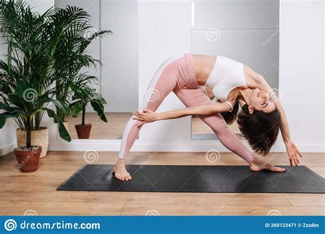 Happy Young Woman Doing Seep Side Bend With Legs Apart Stock Image