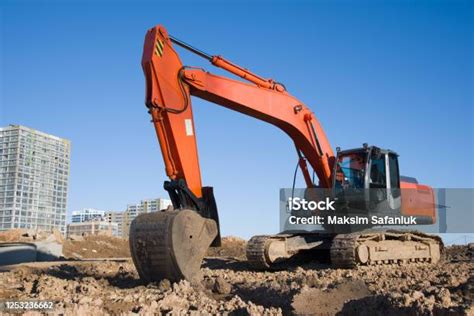 건설 현장에서 토공 하는 동안 굴삭기 백호는 도로 건설을 위해 건설 현장에서 땅을 파고 하수도 파이프 지구 난방을 누워 지구이동 중장비 건설 산업에 대한 스톡 사진 및 기타
