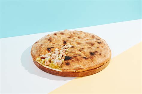 색깔이있는 배경에 치즈 감자 및 닭고기가 들어간 이탈리아 마감 피자 최소한의 스타일로 치즈와 감자를 곁들인 치킨 파이 색상 배경을 가진 미국 피자 배달 개념 감자 요리에