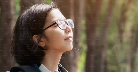 아시아 안경 여성 등산객은 배낭을 메고 자연의 신선한 공기를 호흡합니다 자연 배경에 헤드폰을 끼고 웃고 있는 아름다운 소녀 사진 Unsplash의 틴에이저 이미지