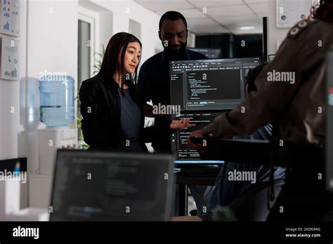 Multi Ethnic Programmers Checking Source Code And Database