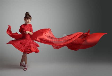Dancing Girl In A Red Dress With Flying Red Satin Fabric Stock Image