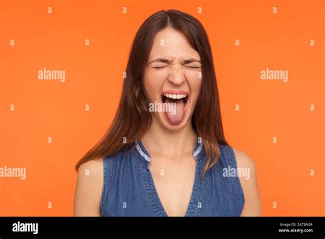 Disobedient Crazy Brunette Woman In Denim Clothes Sticking Out Tongue