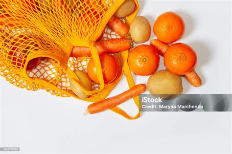 오렌지 메쉬 가방 위에서 본 모습 파머스 마켓의 신선한 야채와 과일 생 감자 생 당근 사과 감귤 오렌지 의식적인 소비 재사용 가능한 가방 끈 가방 채식주의 날 음식 다이어트