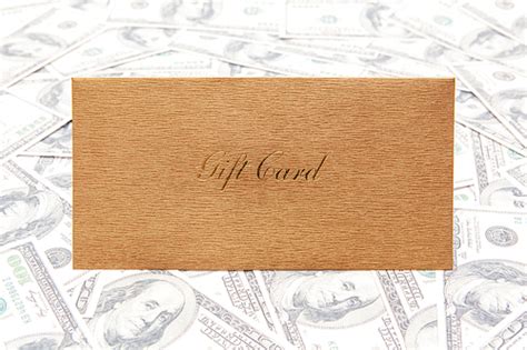 유토이미지 달러 지폐 위에 놓여진 금색 기프트 카드 봉투