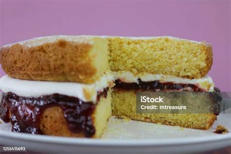 얇게 썬 빅토리아 스폰지 케이크의 이미지 화이트 플레이트에 잼과 버터 크림으로 가득 라일락 핑크 배경에 아이싱 설탕으로 먼지 0명에 대한 스톡 사진 및 기타 이미지 Istock