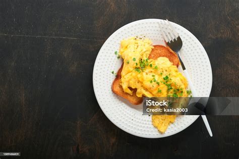 스크램블 에그 푹신하고 버터는 어두운 오래된 나무 배경 위에 흰색 접시에 마이크로 그린 무와 홀란데이즈 소스빵에 계란을 스크램블