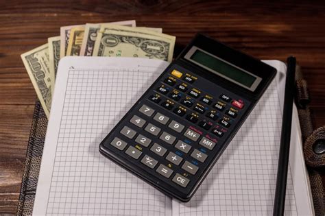Premium Photo Notepad With Dollars Pencil And Calculator On Wooden