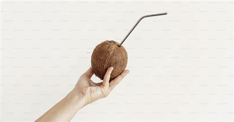 폐기물 제로 흰색 바탕에 금속 짚으로 코코넛을 들고 있다 안녕하세요 여름 휴가 개념입니다 플라스틱 생태 문제를 금지하십시오 열대 섬의 지속 가능한 라이프 스타일