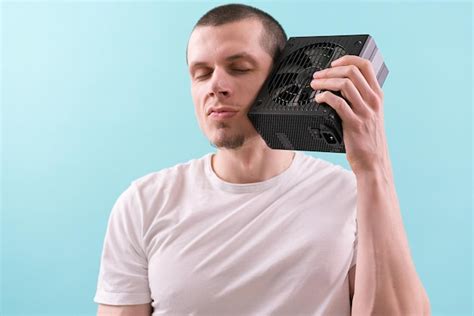 Premium Photo A Man Holds A Computer Power Supply Near His Face On A Blue Background Care