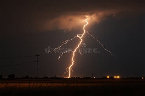 Bright Lightning Strikes Down Over An Open Field At Night During A