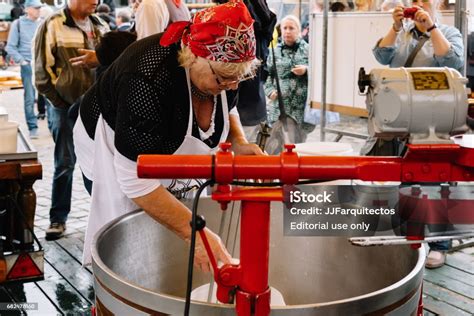 여자 구 다 치즈 시장에서 치즈를 만들기 위한 컨테이너를 청소 하는 전통적인 옷을 입고 매력의 의례와 네덜란드 전통 지금