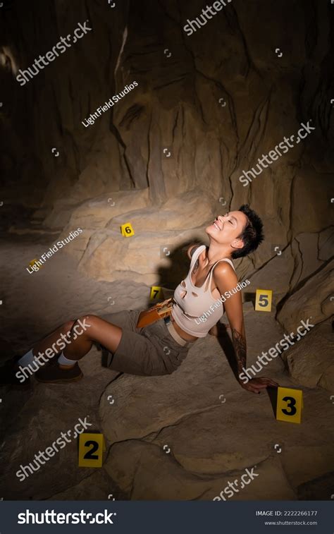 Happy Sexy Archaeologist Sitting Near Numbered Stock Photo