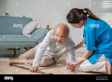 Asian Older Senior Man Falling Down On Lying Floor And Woman Nurse Came