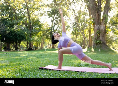 Attractive Young Asian Woman Practice Yoga Exercise In The Park