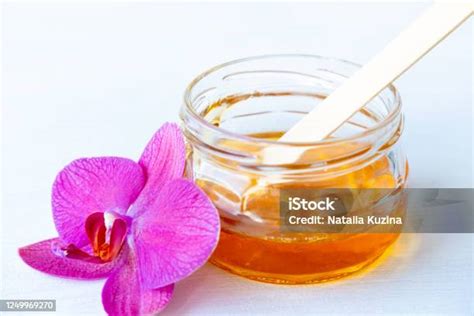 항아리에 나무 왁싱 주걱 막대기로 제거 머리를위한 설탕 페이스트 또는 왁스 꿀 꽃 배경 제모 와 뷰티 컨셉 0명에 대한 스톡