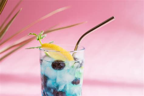 트렌디한 그림자가 드리워진 핑크색 배경에 화려한 여름 블루 쿠라카오 칵테일을 클로즈업합니다 신선한 딸기로 상쾌한 음료 비건 음료 0명에 대한 스톡 사진 및 기타 이미지