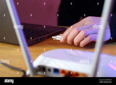 Inserting A Gsm Modem Into A Laptop By A Person In A Black Sweatshirt On A Pink Background Stock