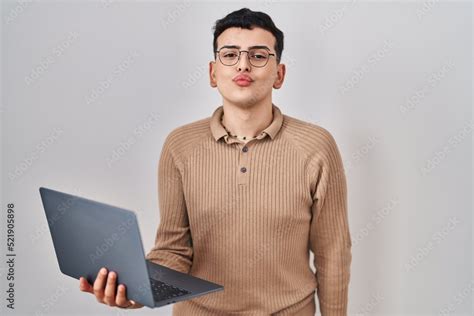 Non Binary Person Using Computer Laptop Looking At The Camera Blowing A Kiss On Air Being Lovely
