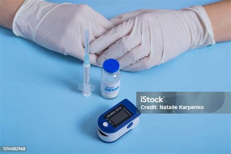 의료 개념 흰색 장갑 펄스 옥시미터 코로나 바이러스 백신 주사기에 파란색 배경 의사의 손에 바이러스 보호 개념 코로나바이러스펄스