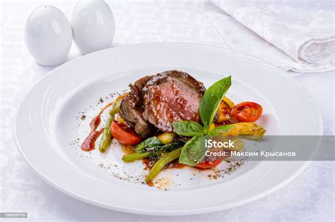 흰 식탁에 흰 접시에 구운 야채를 곁들인 쇠고기의 메달리온 돼지고기에 대한 스톡 사진 및 기타 이미지 돼지고기 메달 고기 원형 펜던트 Istock