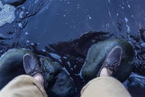 Green Stone Backdrop With Male Feet Wearing Top Siders Over Water Photo