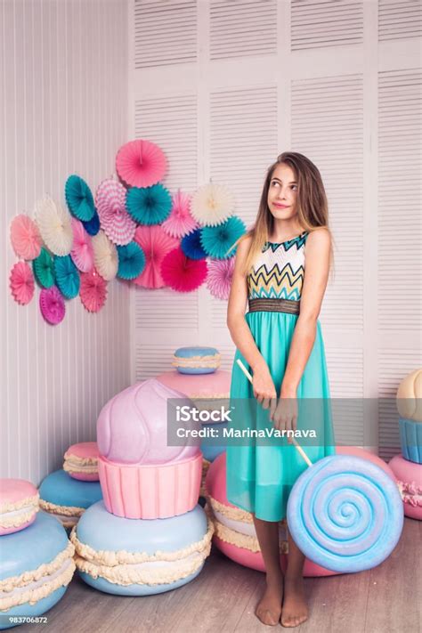 파란색 드레스를 입고 아름 다운 소녀 마카롱의 장식과 스튜디오에 손에 거 대 한 사탕을 개최 공간에 복사 합니다 감정에 대한 스톡 사진 및 기타 이미지 Istock