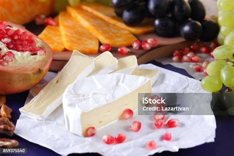 카망베르 치즈 대리석된 치즈 오렌지 치즈 다른 치즈 어두운 파란색 포도 붉은 석류 녹색 포도 땅콩 복고 스타일을 작성 하기 위한 빈 자리와 나무 보드에 호두 가을에 대한