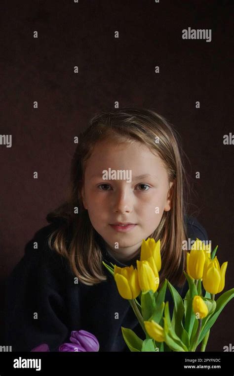 Pretty Girl With Long Hair On A Dark Background Bent Over Yellow And